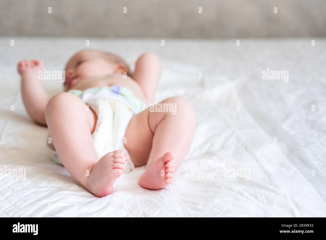 Baby feet in focus on a comfy bed. Concept of infant growth and ...