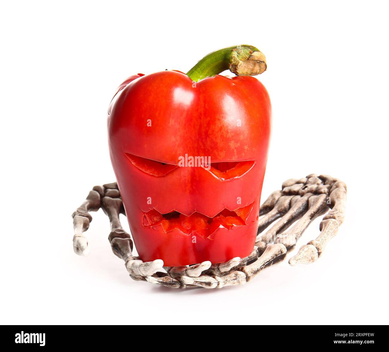 Carved bell pepper for Halloween with skeleton hands on white ...