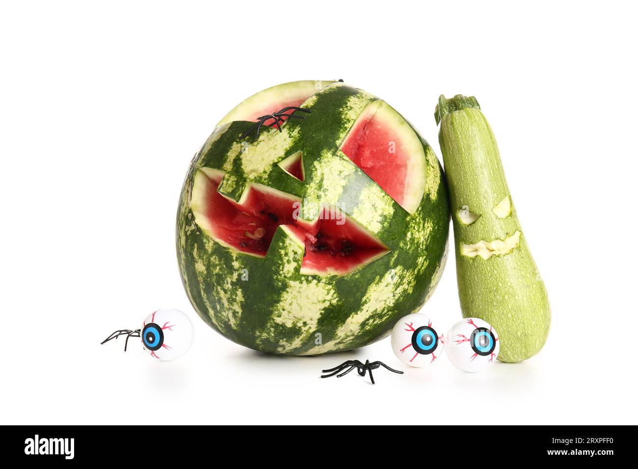 Carved watermelon, zucchini for Halloween with eyes and spiders on ...