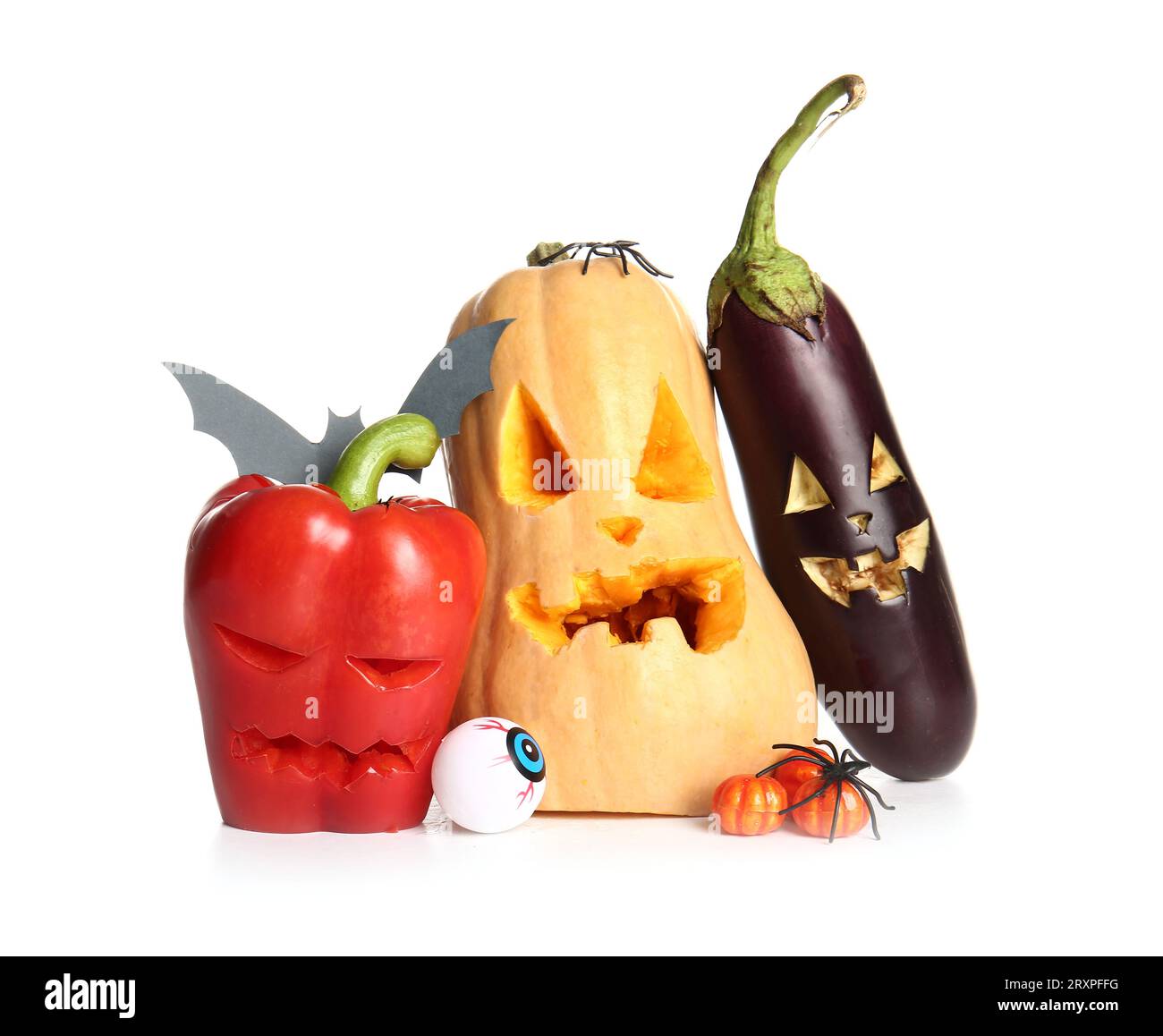 Carved vegetables for Halloween with candies, spiders, bat and eye on ...
