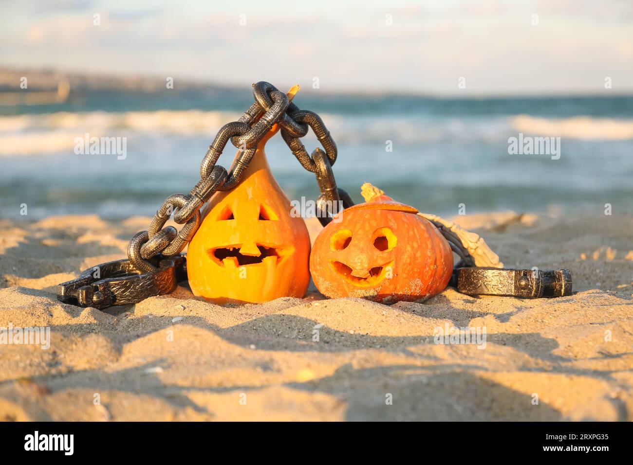 Carved pumpkins for Halloween with chain on beach Stock Photo - Alamy