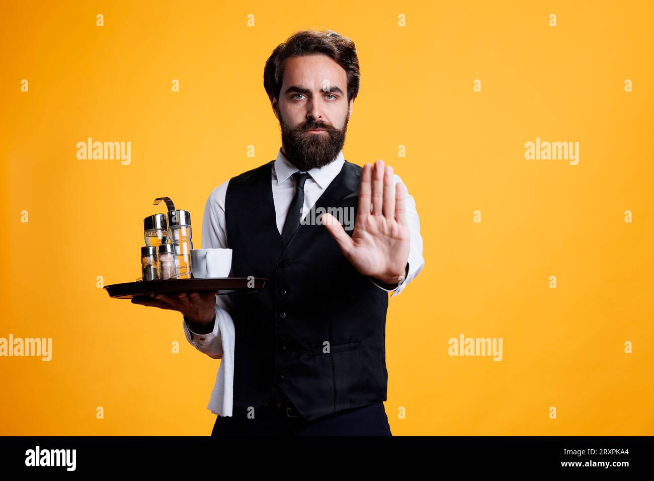 Expert waiter raising palm to do stop sign in studio, expressing ...