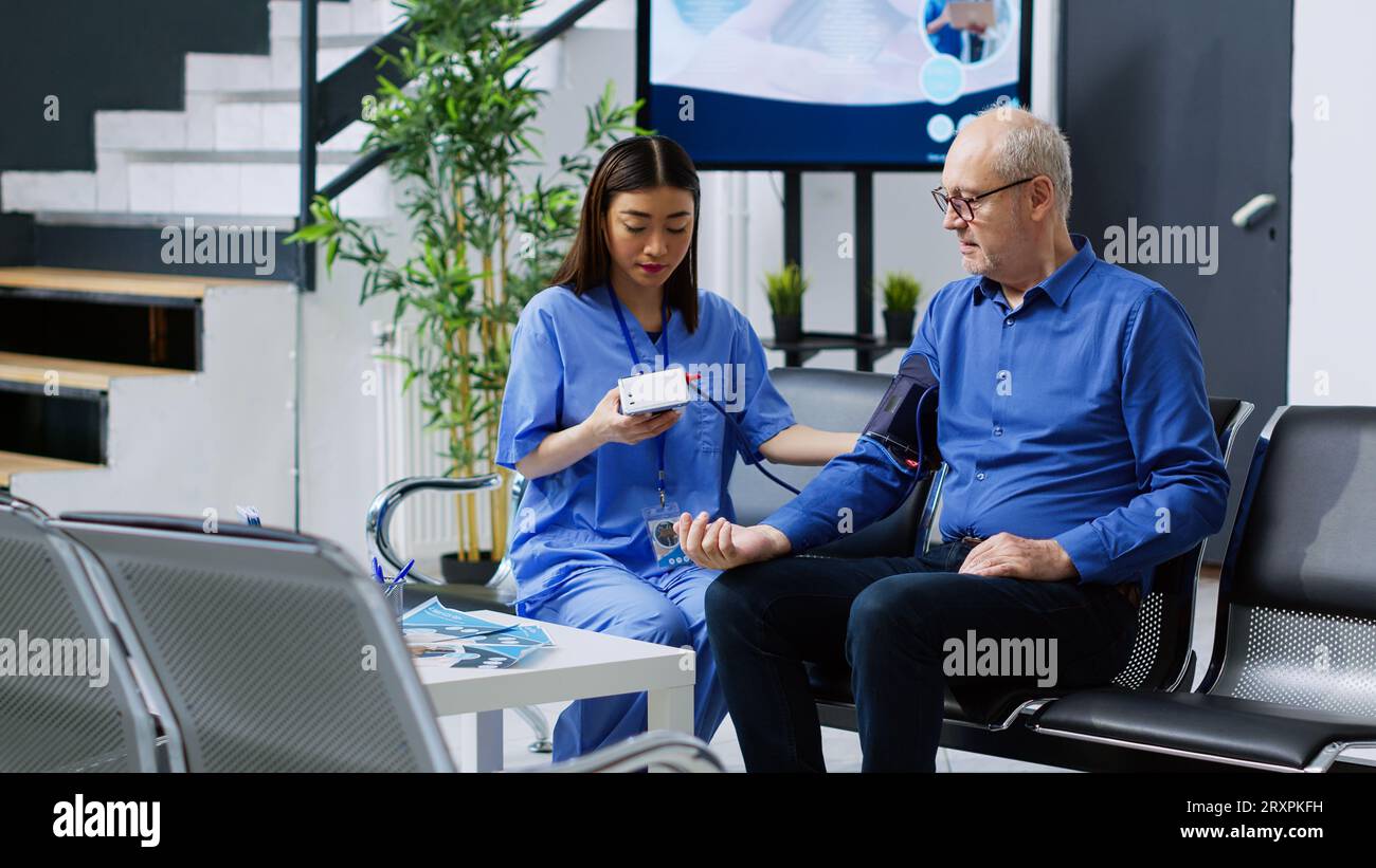 Nurse checking patient cardiac pulse during cardiology examination in ...