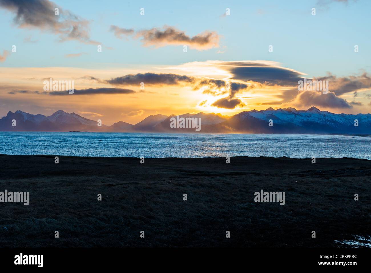 Icelandic lakeside setting at sunset with golden sky and frosty ...