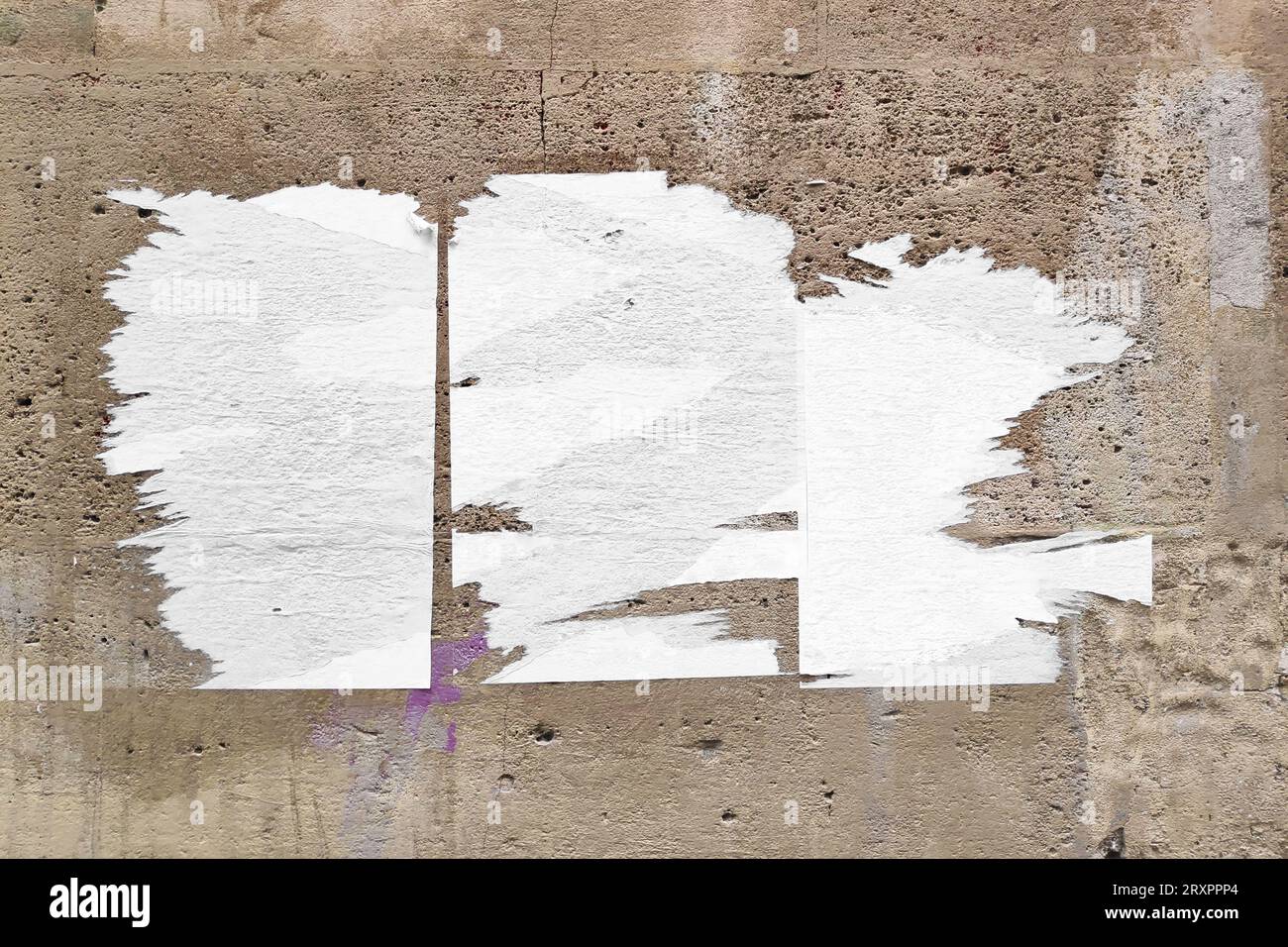 Full-frame weathered limestone wall with three torn blank posters Stock ...