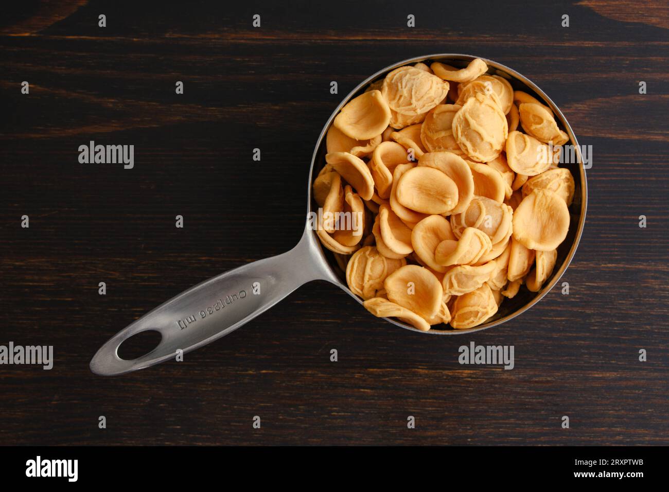 Dried Orange orecchiette Pasta in a Measuring Cup: Uncooked orecchiette ...