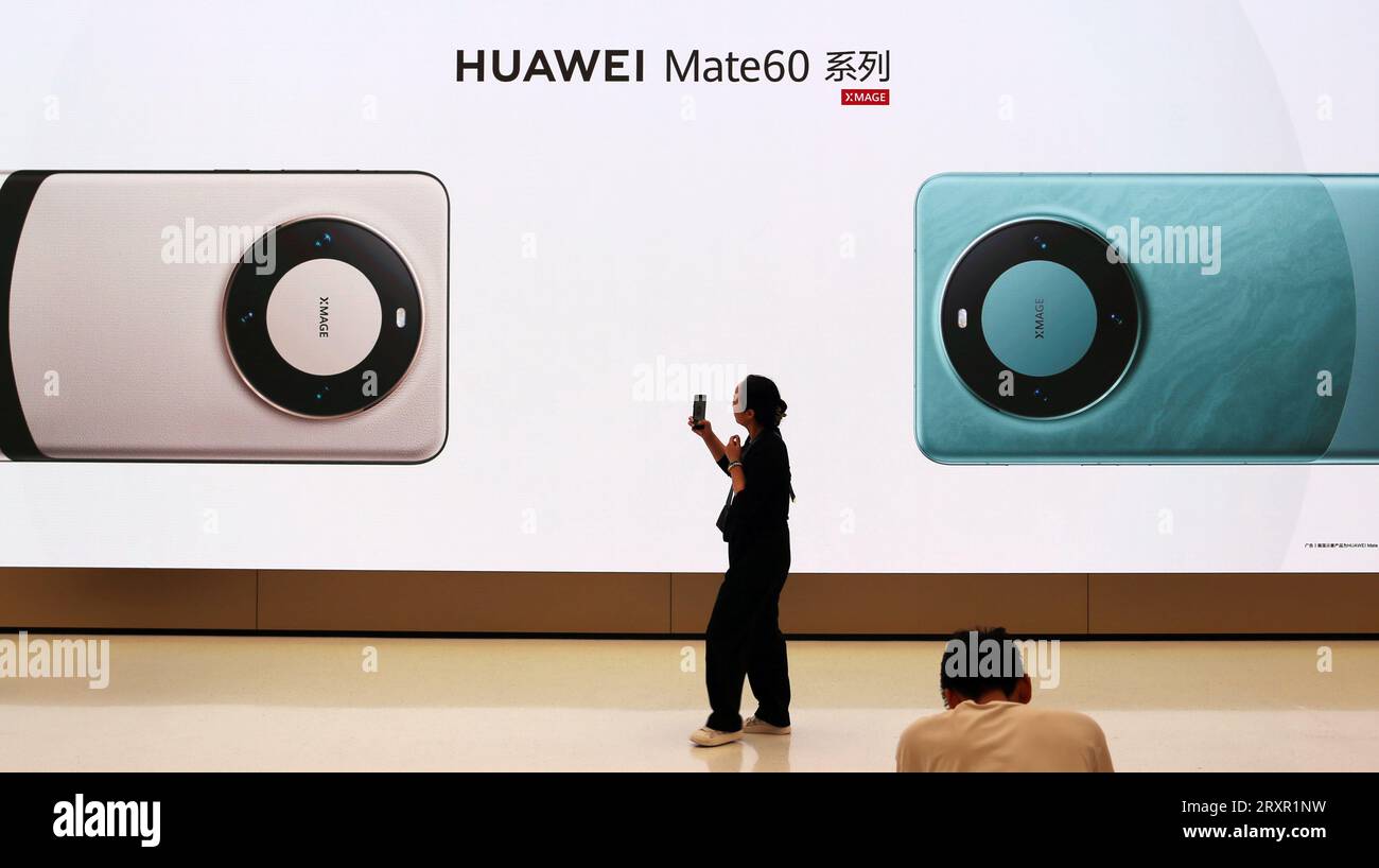 SHANGHAI, CHINA - SEPTEMBER 24, 2023 - Visitors pass a poster of Huawei ...