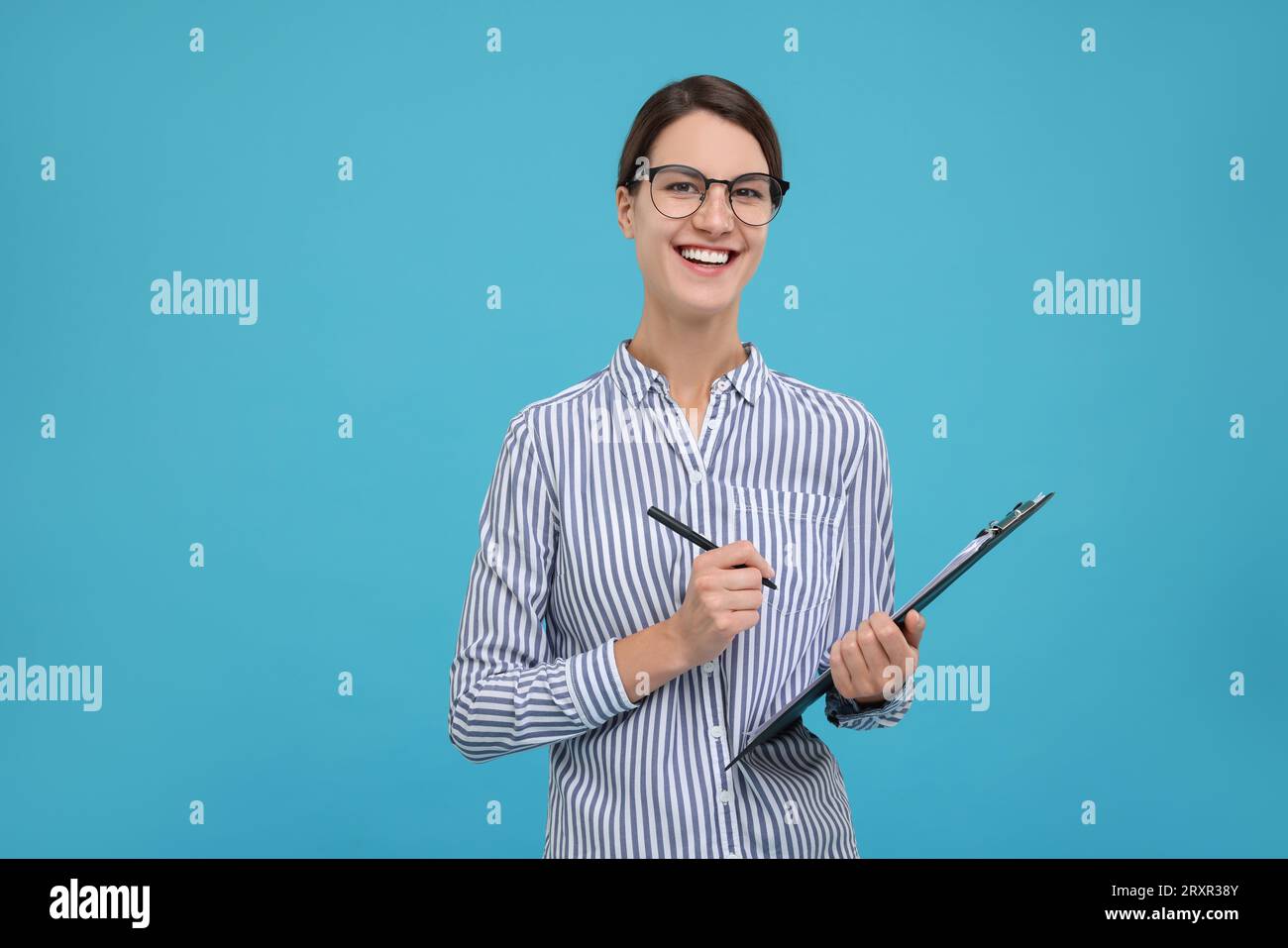 Happy secretary with clipboard and pen on light blue background Stock ...