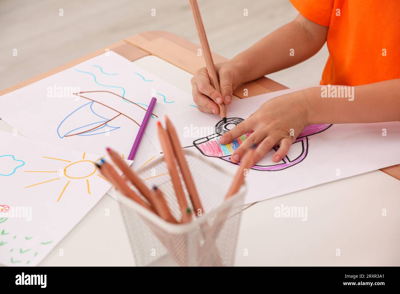 Little child drawing picture on paper at desk, closeup. Kindergarten ...