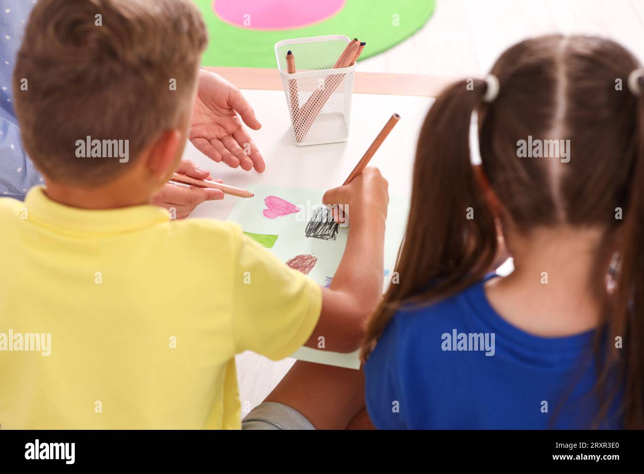 Little children drawing at desk, back view. Kindergarten activity Stock ...