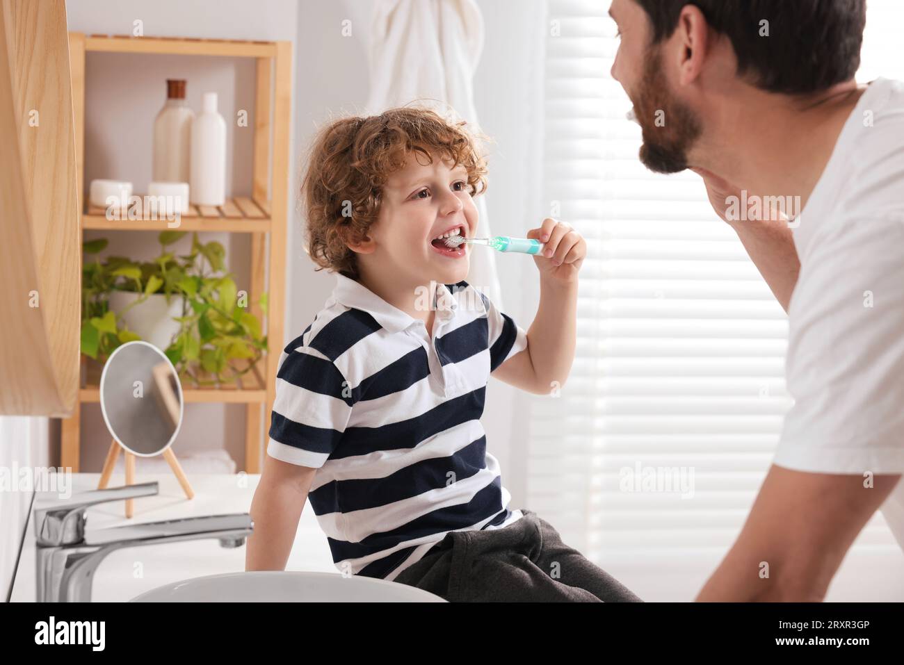 Father and his son brushing teeth together in bathroom Stock Photo - Alamy