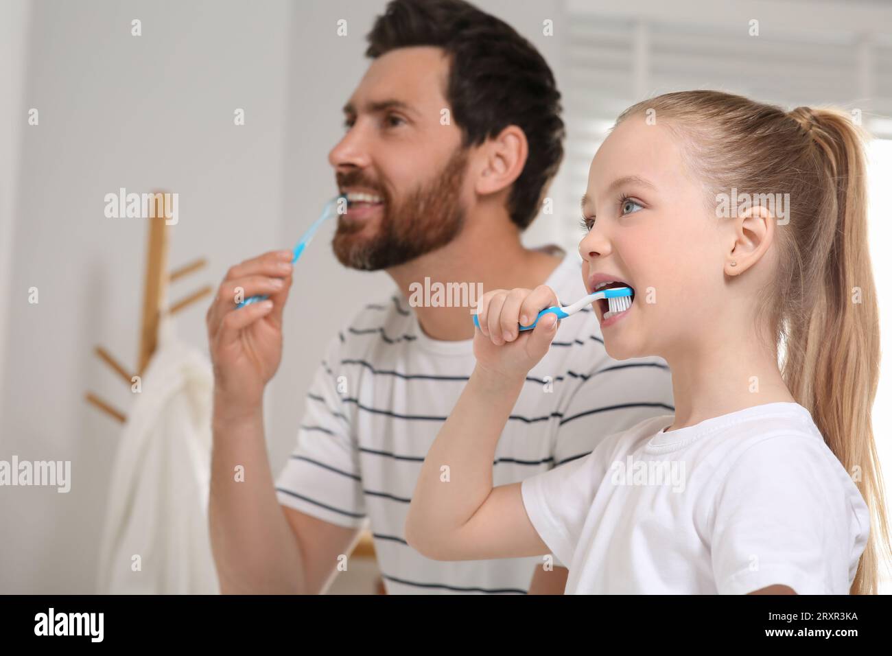 Father and his daughter brushing teeth together in bathroom Stock Photo ...
