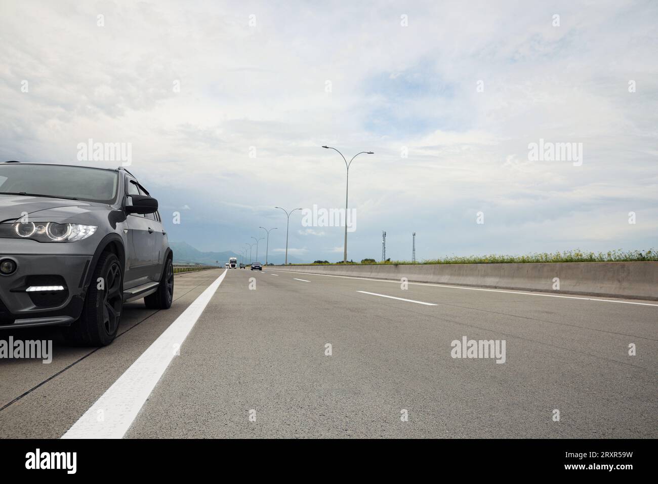 Grey modern car parked on asphalt road Stock Photo - Alamy