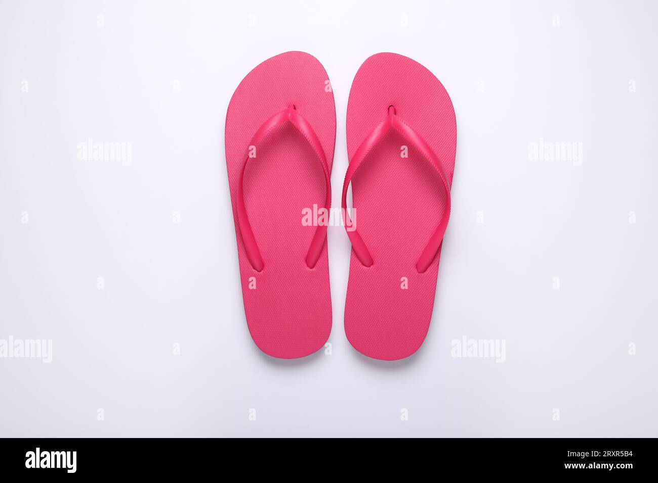 Stylish pink flip flops on white background, top view Stock Photo - Alamy