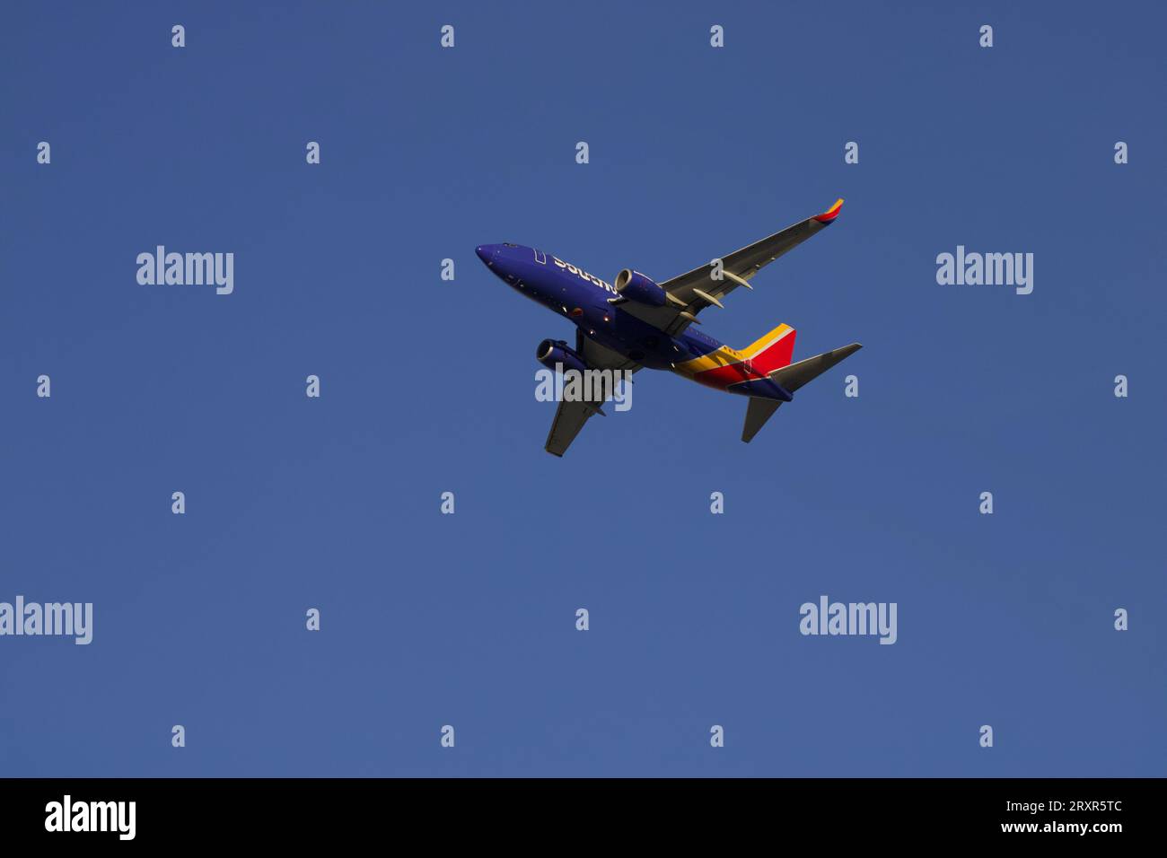 Southwest 737 flying against cloudless blue sky, underbelly view Stock ...