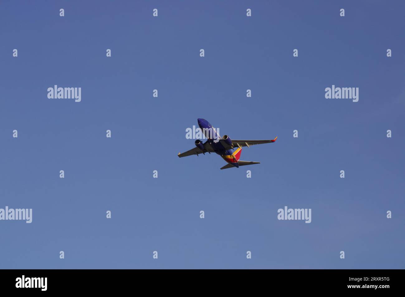 Southwest 737 flying against cloudless blue sky, underbelly view Stock ...