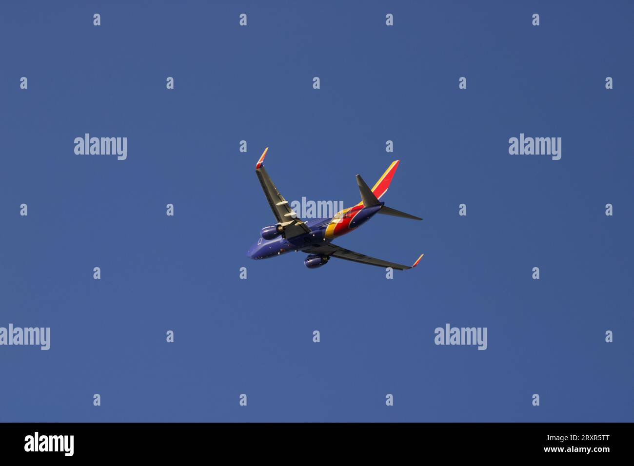 Southwest 737 flying against cloudless blue sky, underbelly view Stock ...