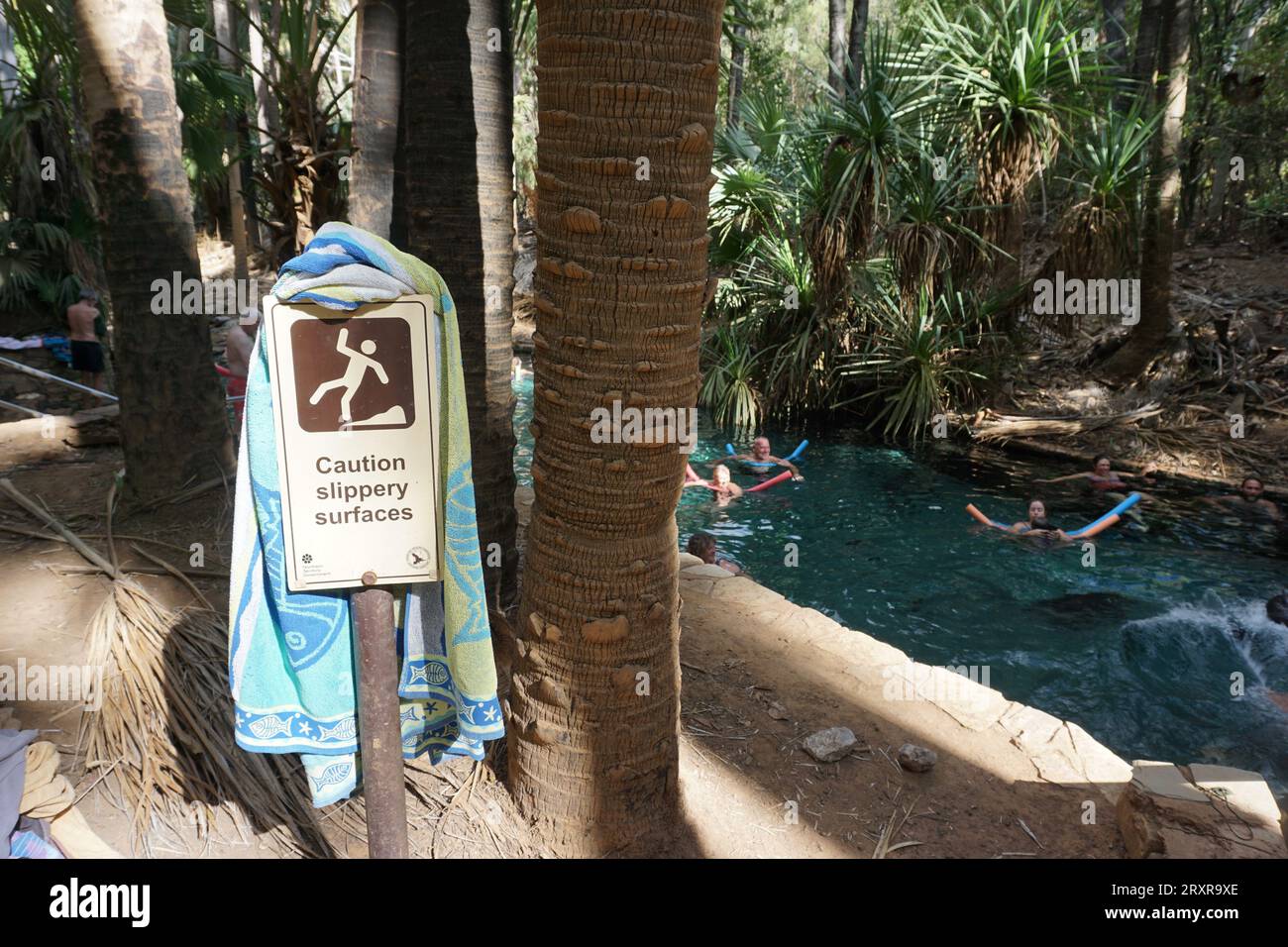sign warning Caution Slippery Surfaces with people floating in water ...