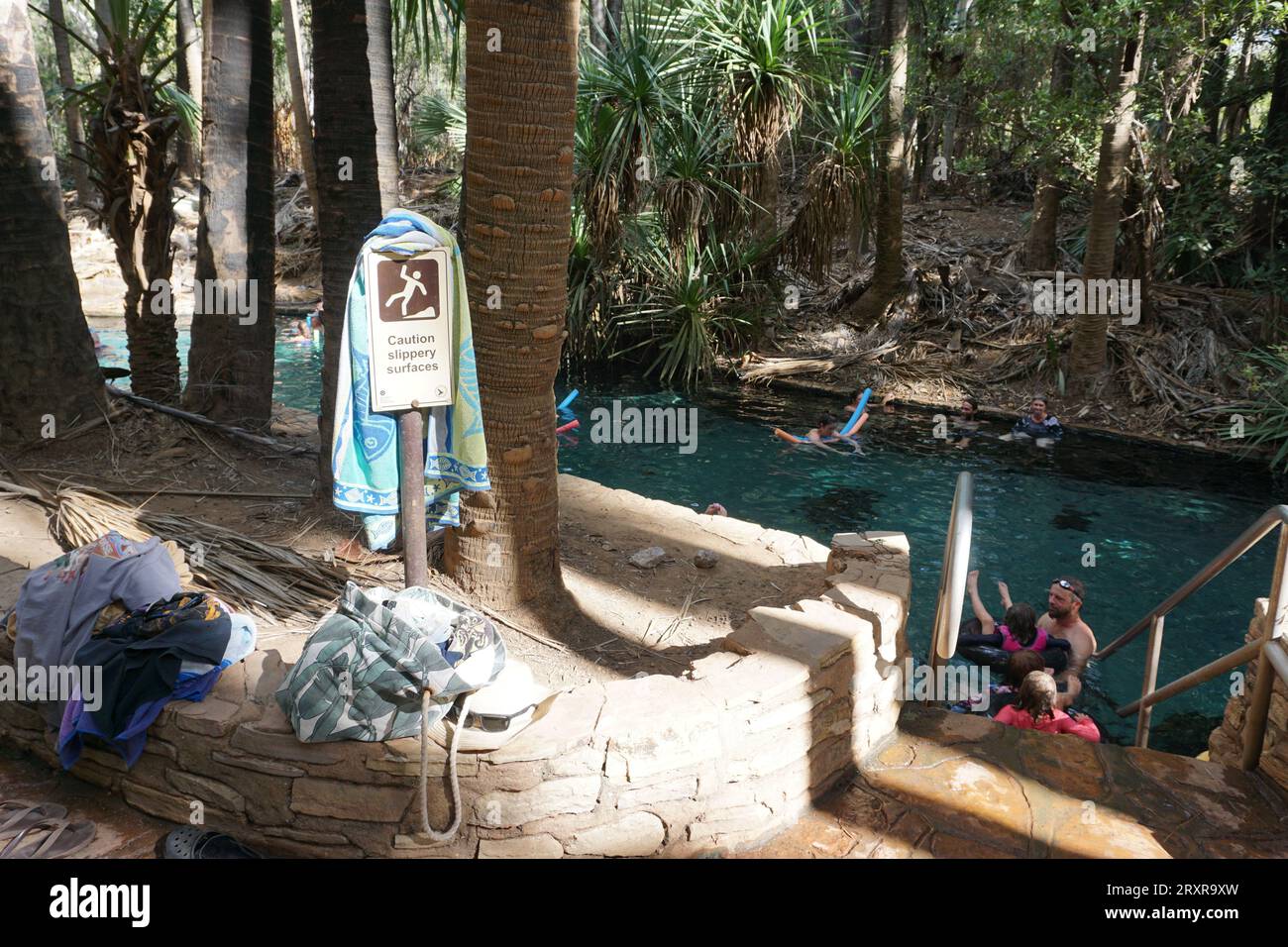 sign warning Caution Slippery Surfaces with people floating in water ...