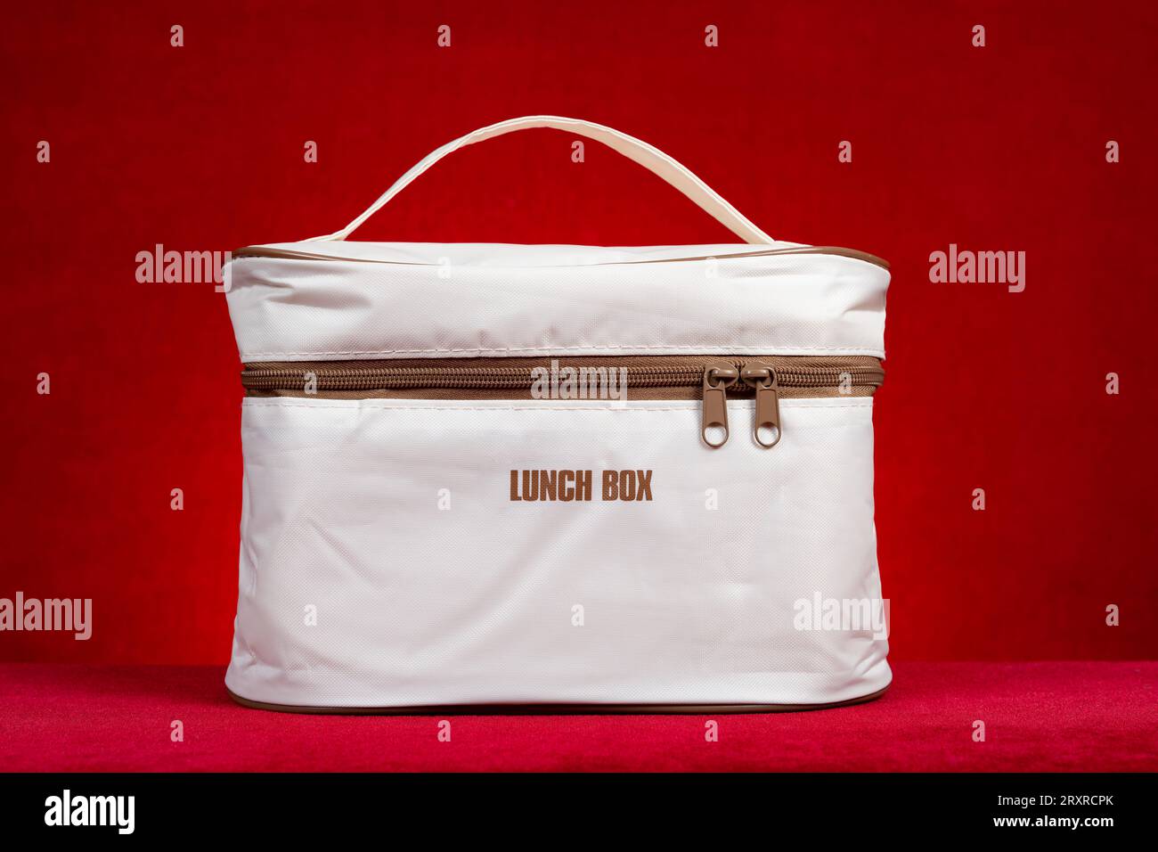 beige color lunch box carrier or insulation bag on a red background ...