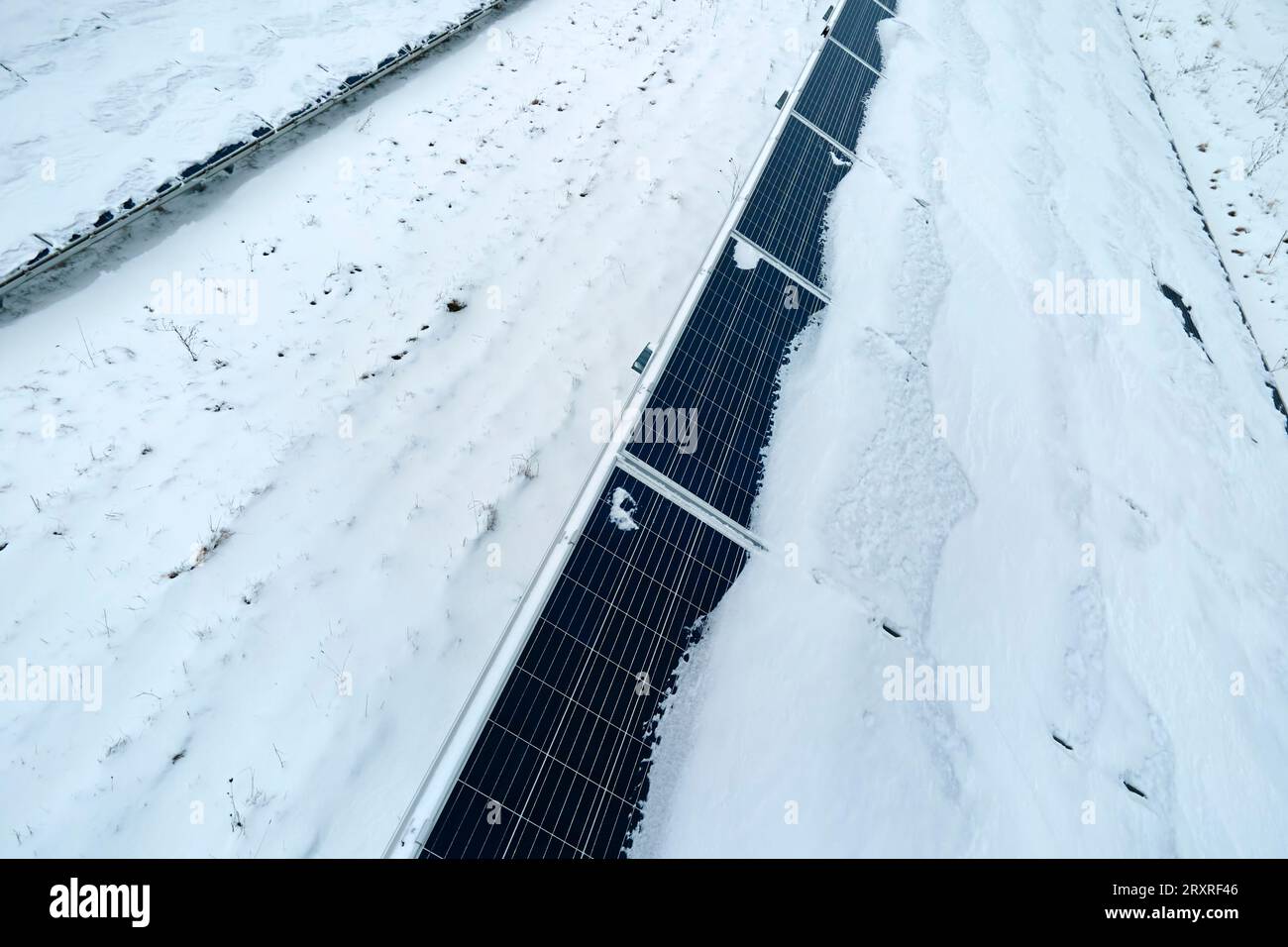 Aerial view of snow covered sustainable electric power plant with rows ...