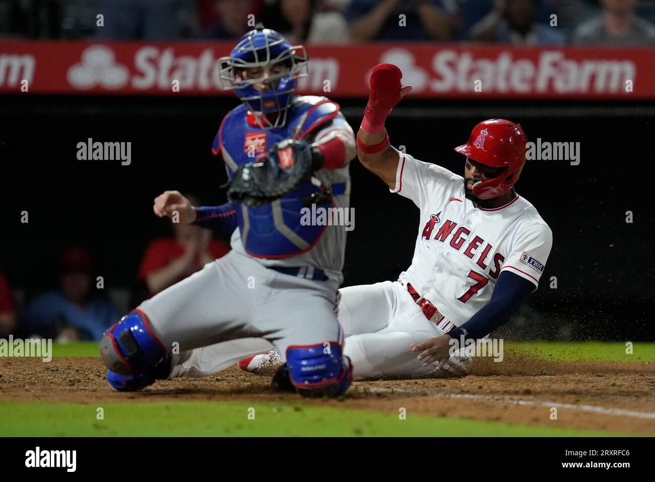 Los Angeles Angels' Jo Adell (7) scores ahead of a throw to Texas ...