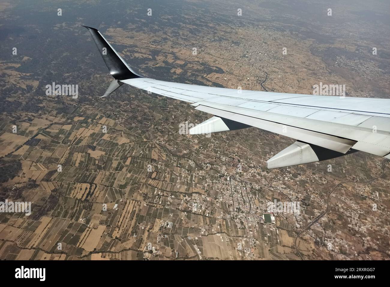 View through airplane window of commercial jet plane wing flying high ...