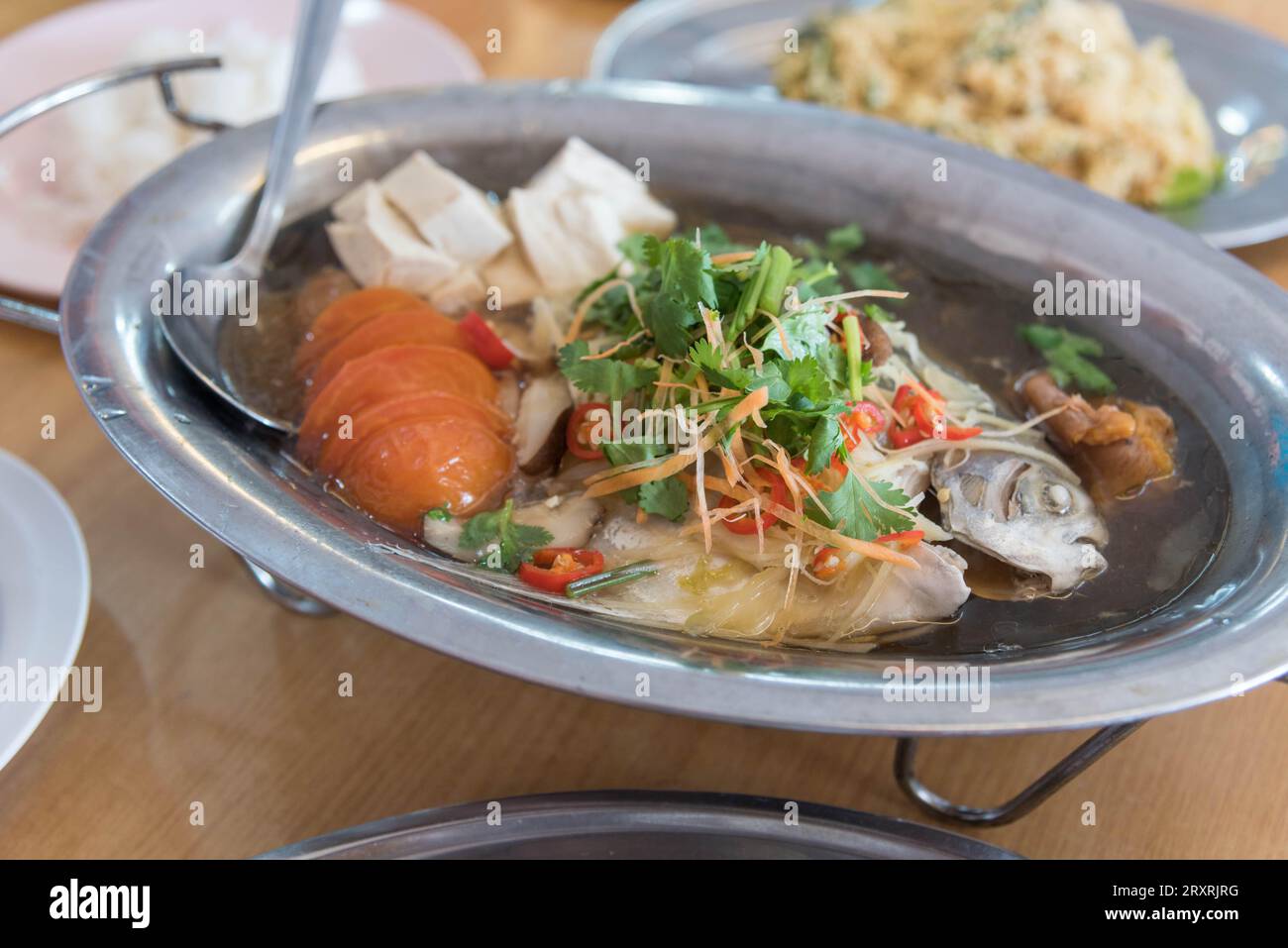A soy sauce and tofu steamed fish dish, served as a part of a Chinese ...