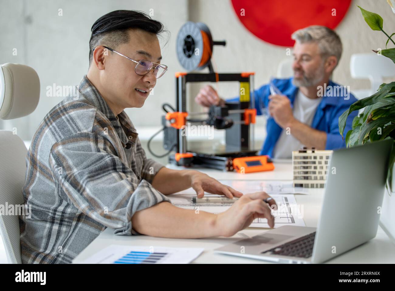 Architects working with 3D printer and projecting house model, drawing ...
