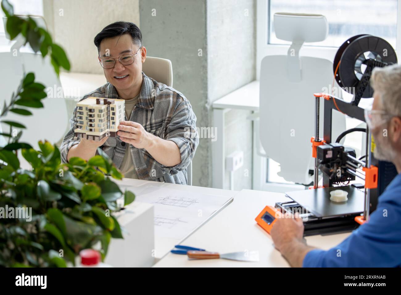 Architects making house model working with 3D printer, creating process ...