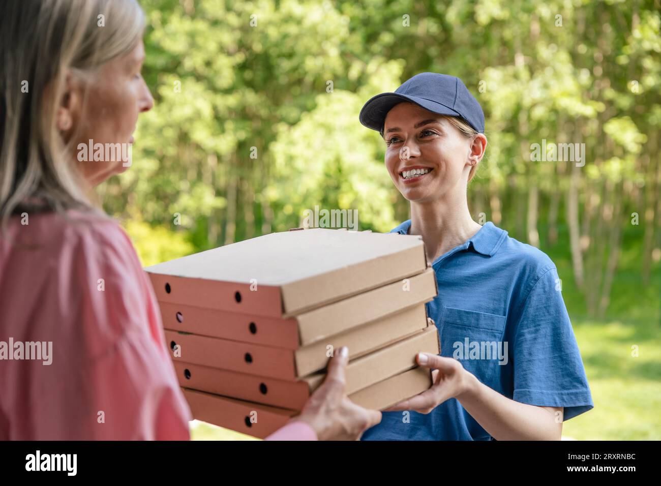 Female courier delivering pizza to client home Stock Photo - Alamy