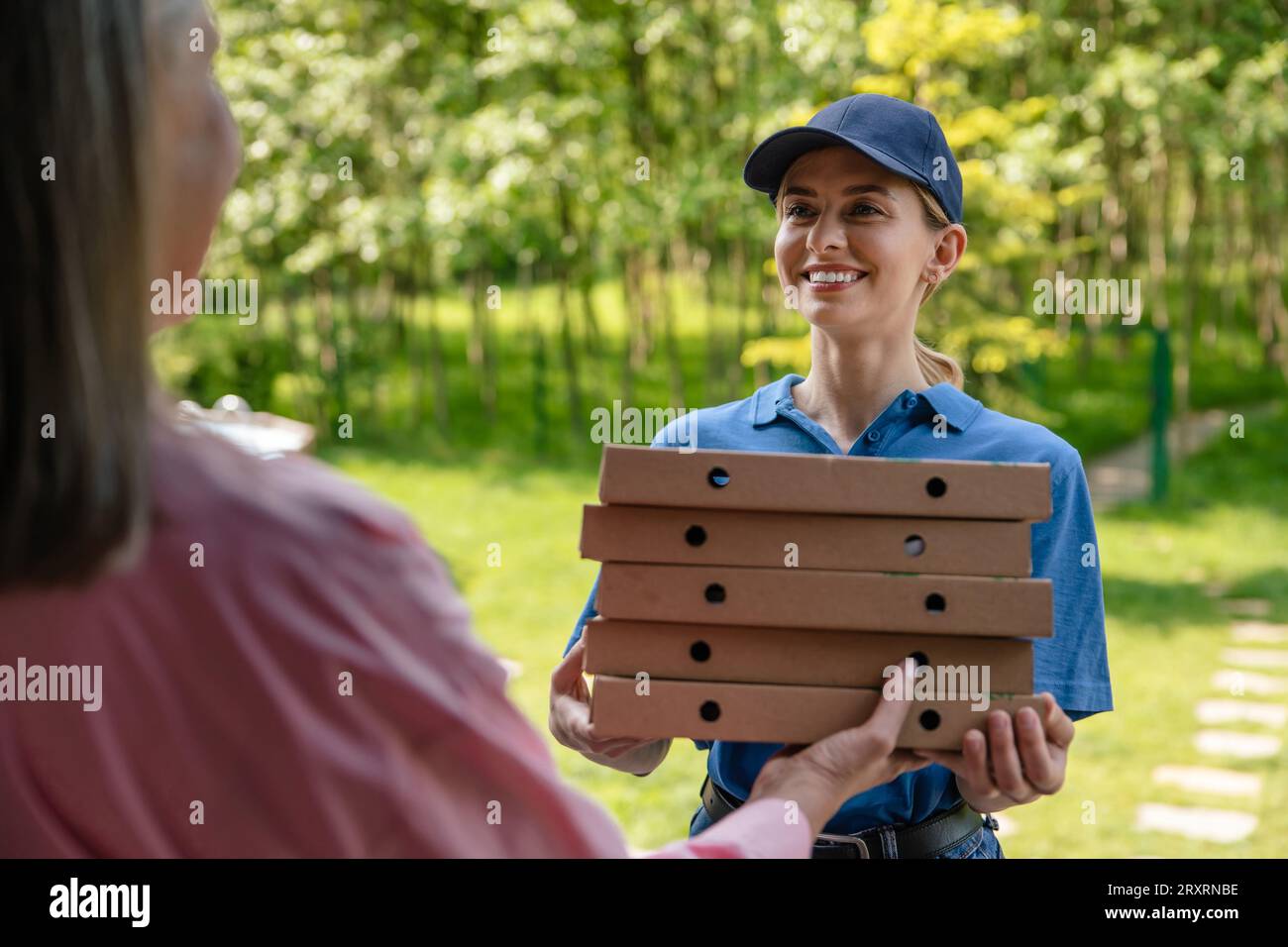 Female courier delivering pizza to client home Stock Photo - Alamy