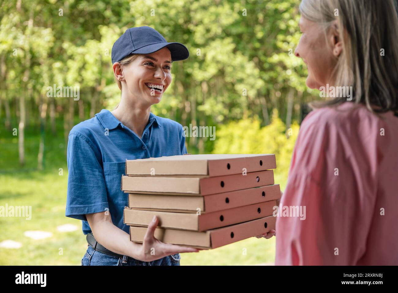Female courier delivering pizza to client home Stock Photo - Alamy