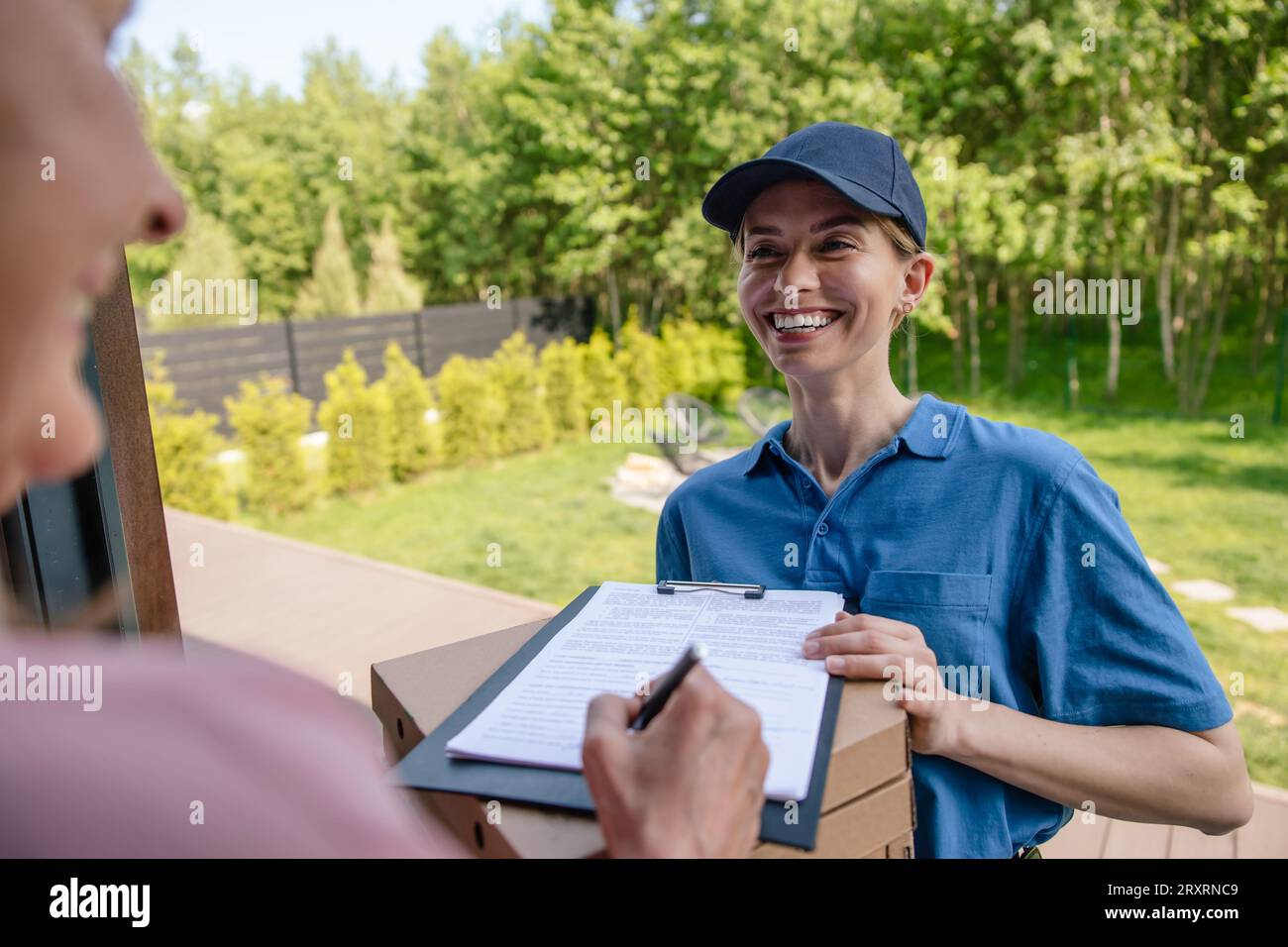 Courier delivering parcel, customer signs the delivery documents Stock ...