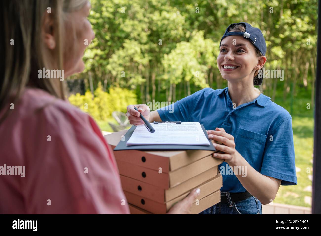Courier delivering parcel, customer signs the delivery documents Stock ...