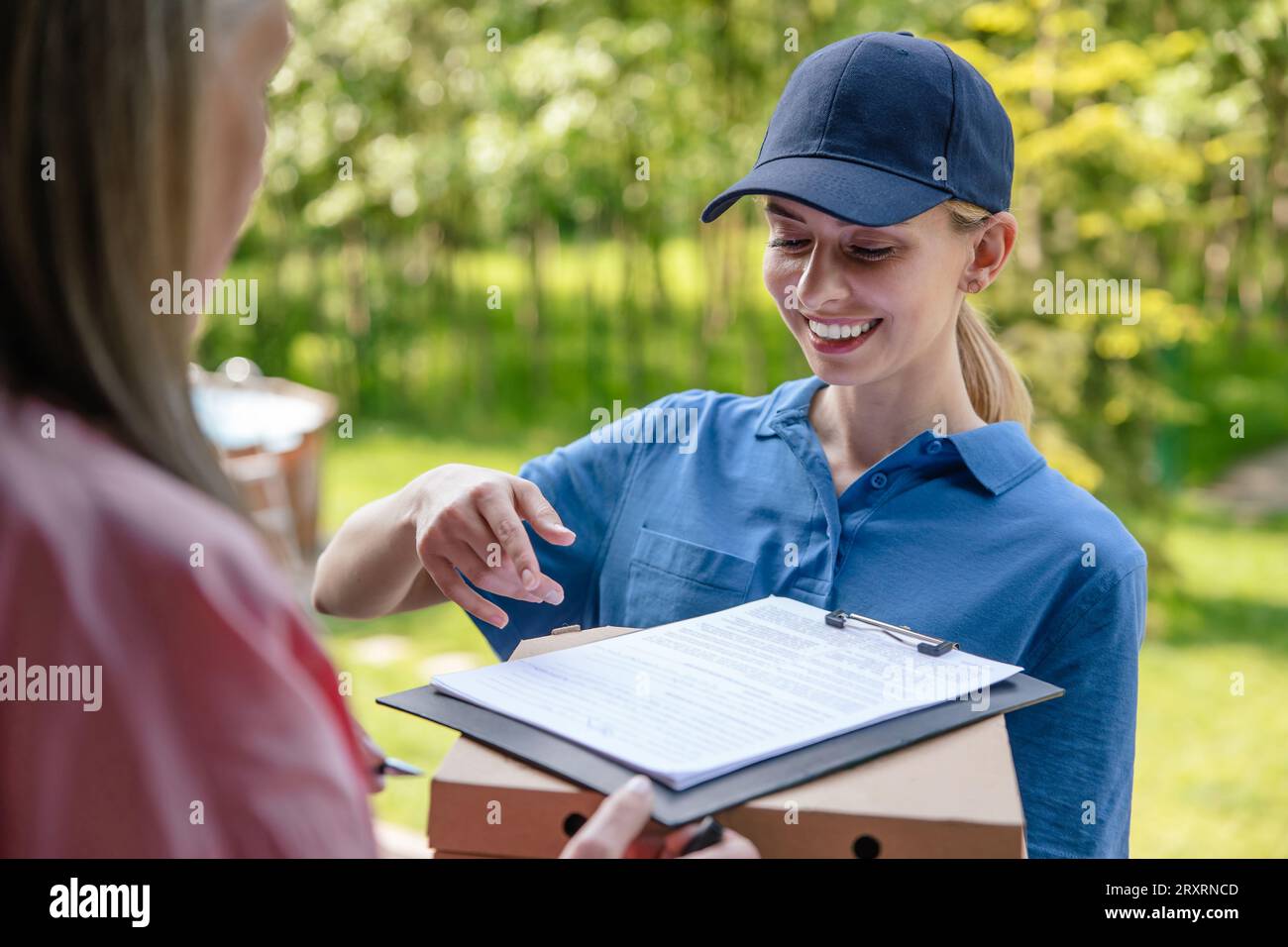 Courier delivering parcel, customer signs the delivery documents Stock ...