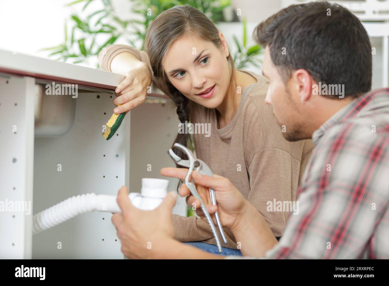Woman fixing plumbing under sink hi-res stock photography and images ...