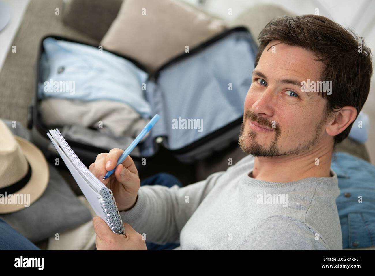 man packing suitcase with a checklist Stock Photo - Alamy