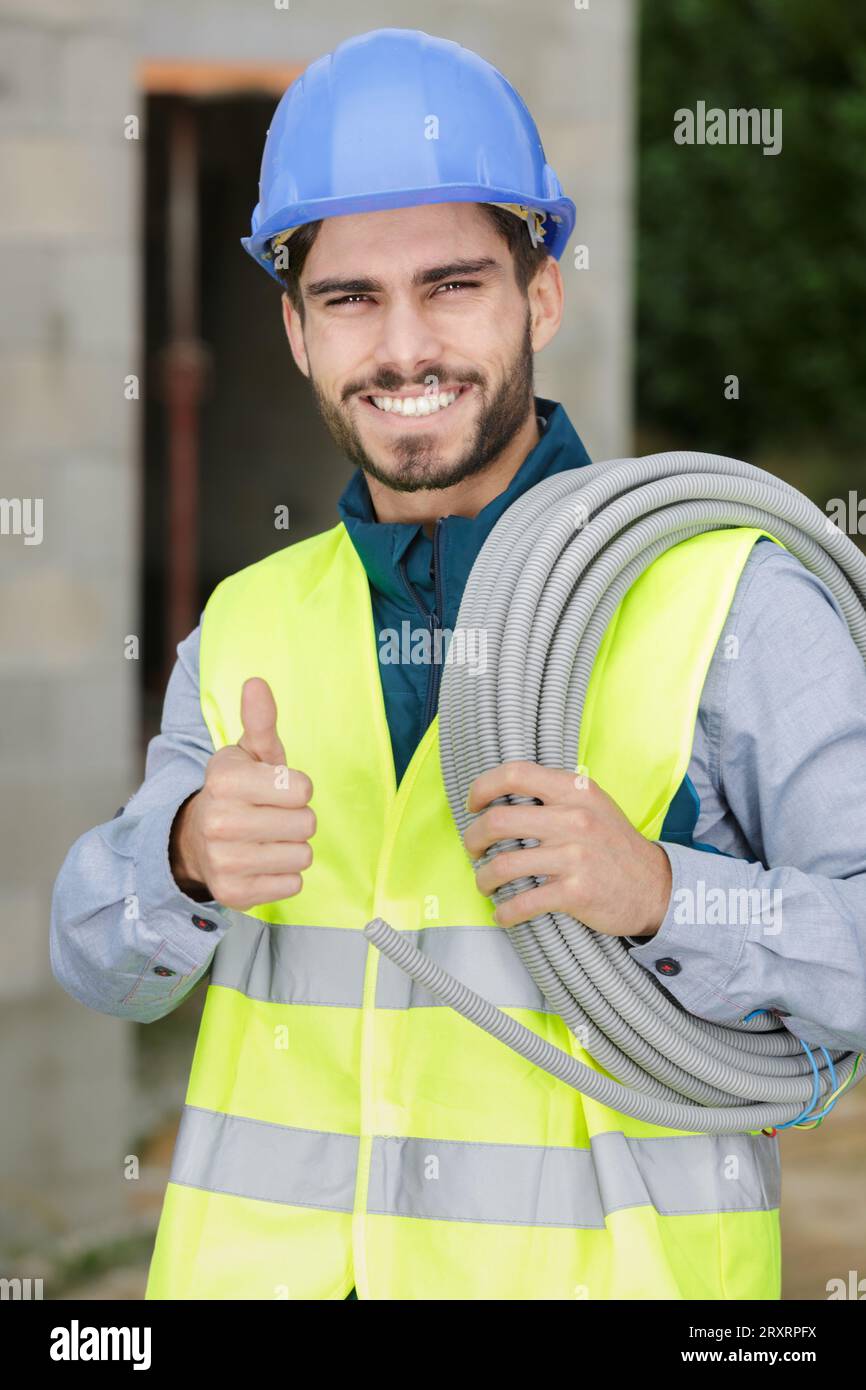 optimistic worker builder shows thumb up Stock Photo - Alamy