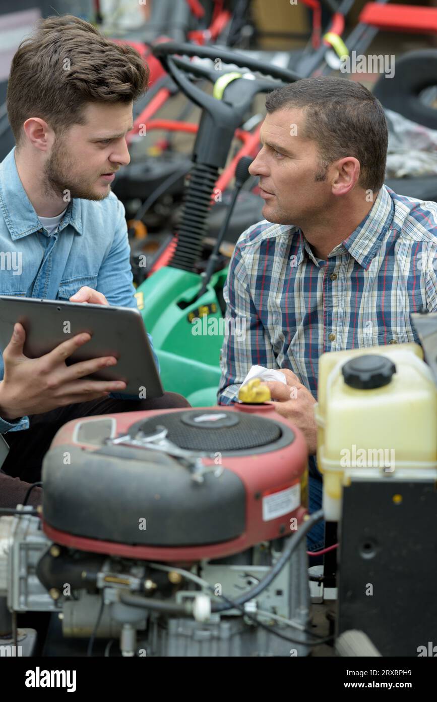 agricultural mechanic with trainee holding tablet Stock Photo - Alamy
