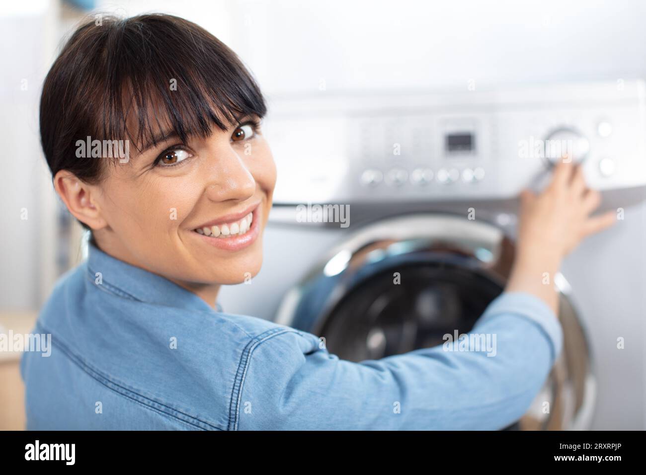 happy housewife woman in laundry room with washing machine Stock Photo ...