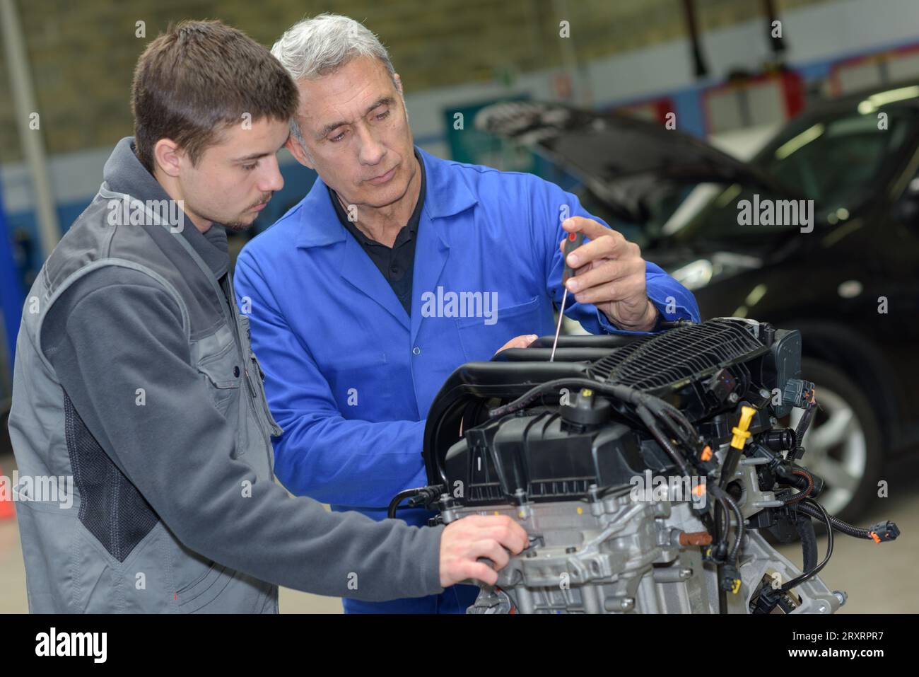 student with instructor repairing a car during apprenticeship Stock ...