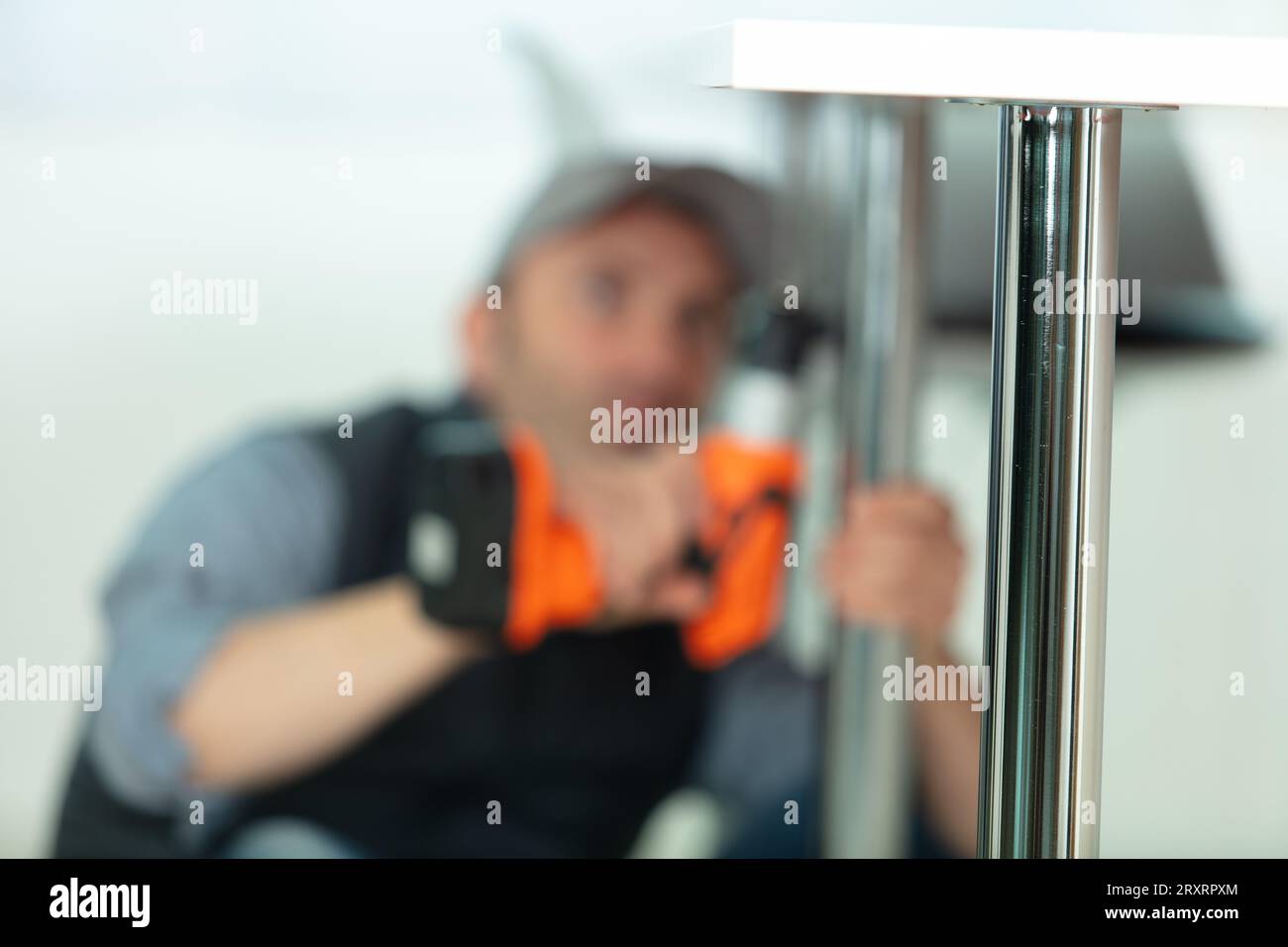 man fixing the leg of the table Stock Photo - Alamy