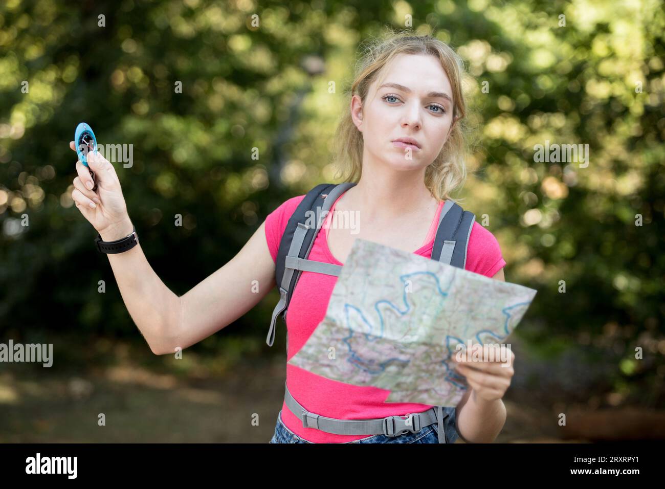 portrait of young female hiker holding compass and map Stock Photo - Alamy
