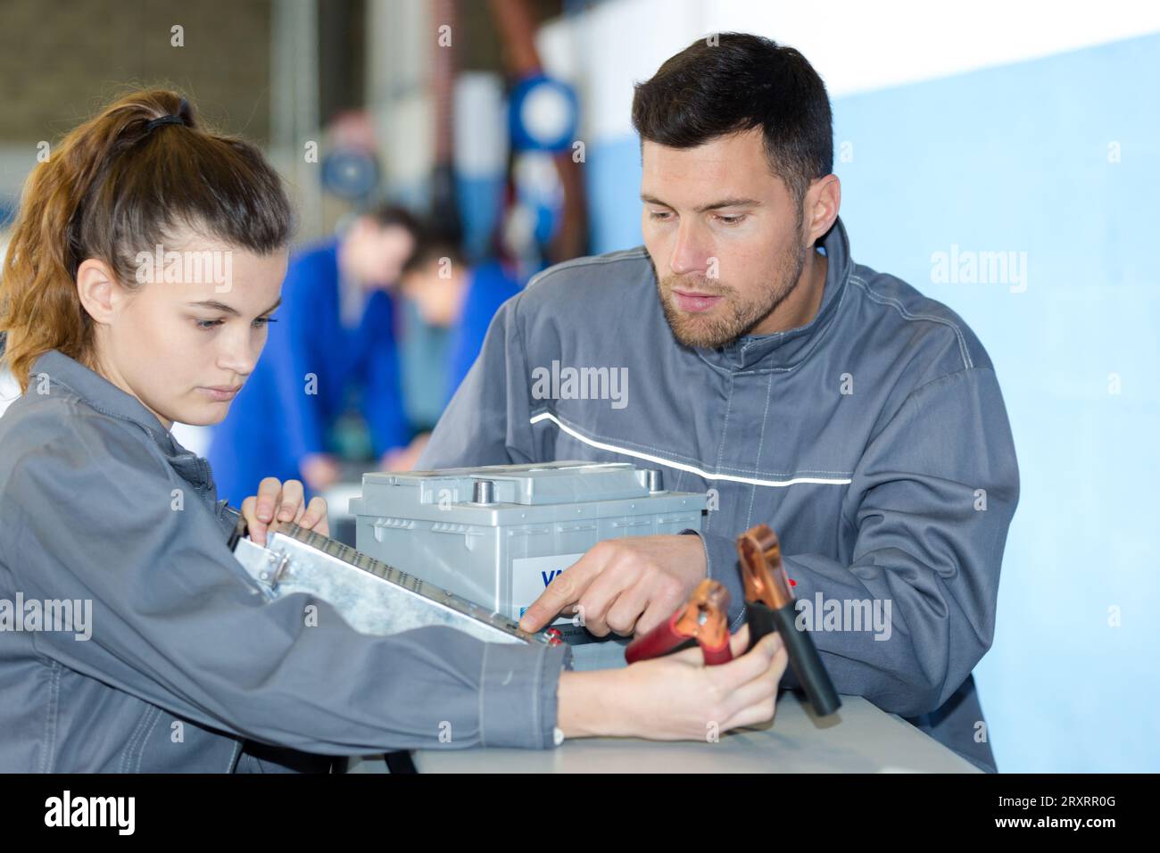female and male auto mechanic changing a car battery Stock Photo - Alamy
