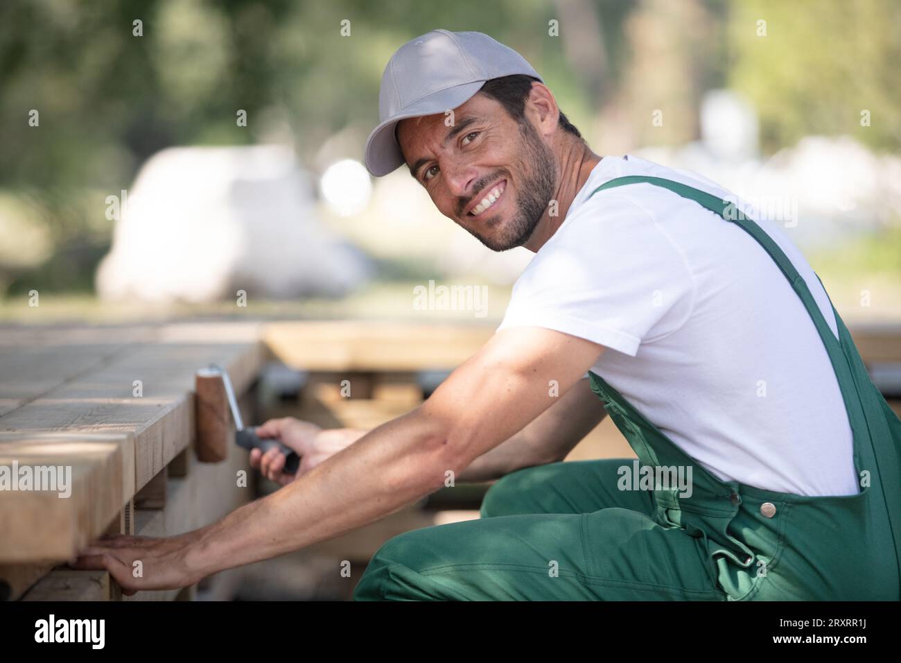 man applying wood preserver with a paint roller Stock Photo - Alamy