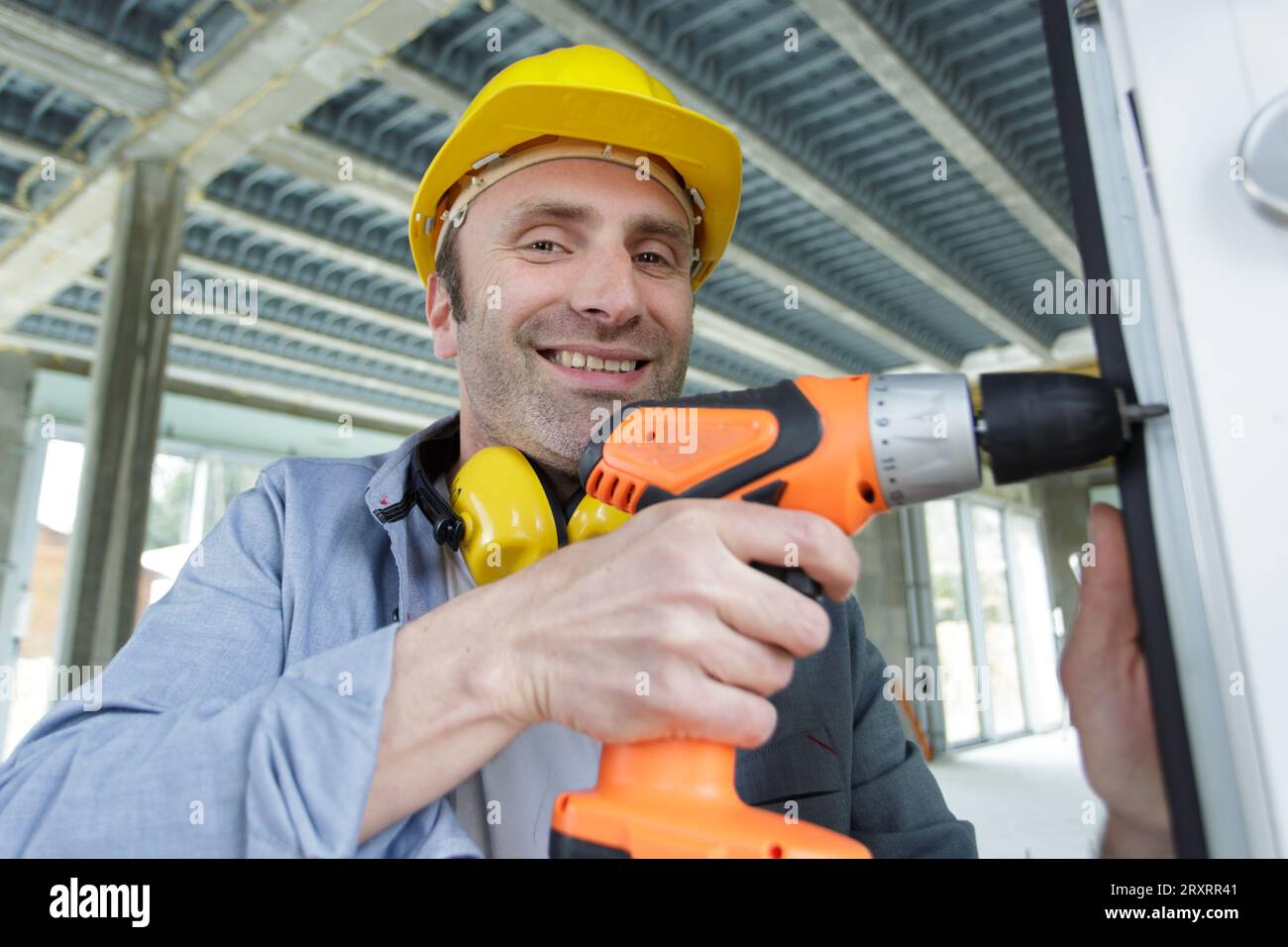 a man drilling a window frame Stock Photo - Alamy