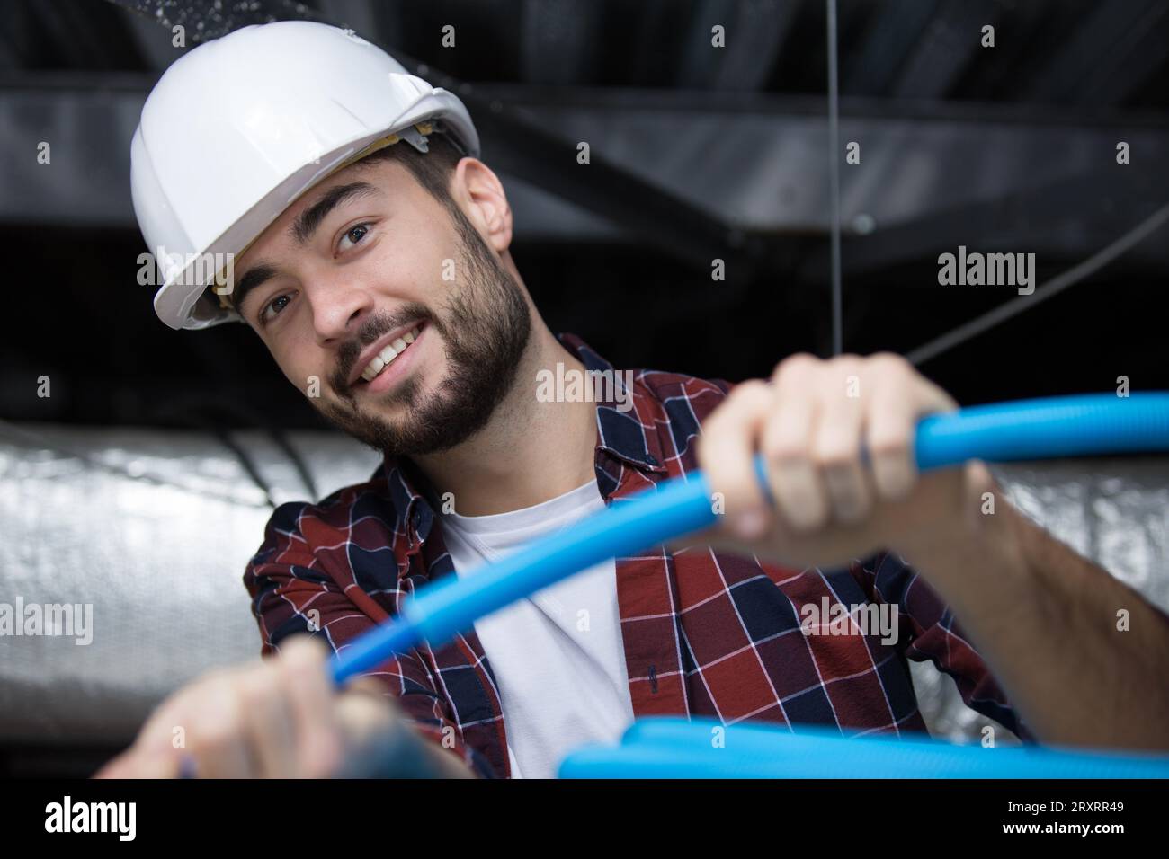 man builder holding blue pipes in construction site Stock Photo - Alamy