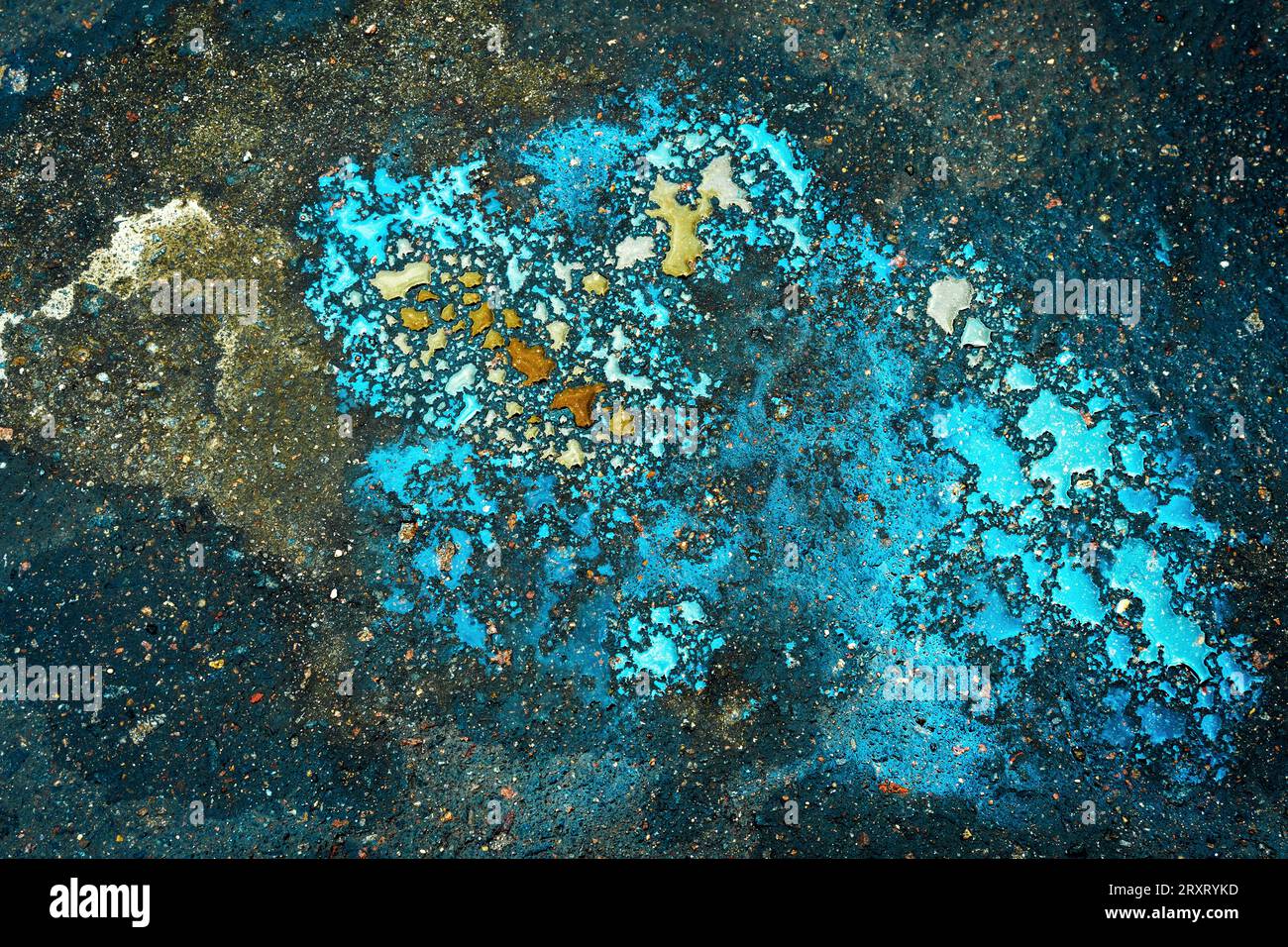 Colored oil stains close-up, color of a gasoline stain on asphalt as a ...