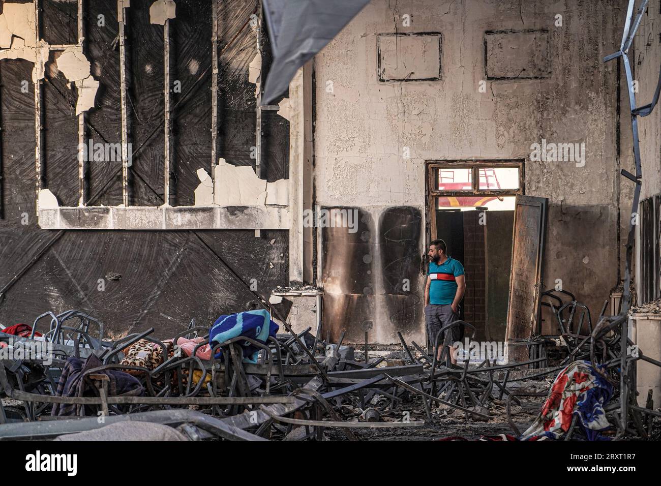 27 September 2023, Iraq, Hamdaniya: A man looks through the burnt down ...